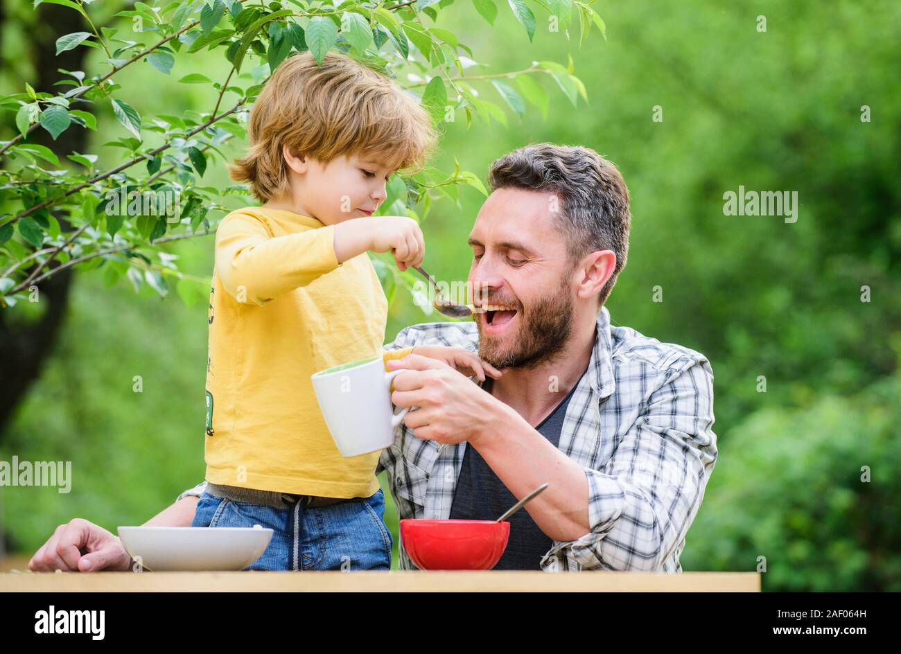 father and son eating outdoor. We like spending time together ...