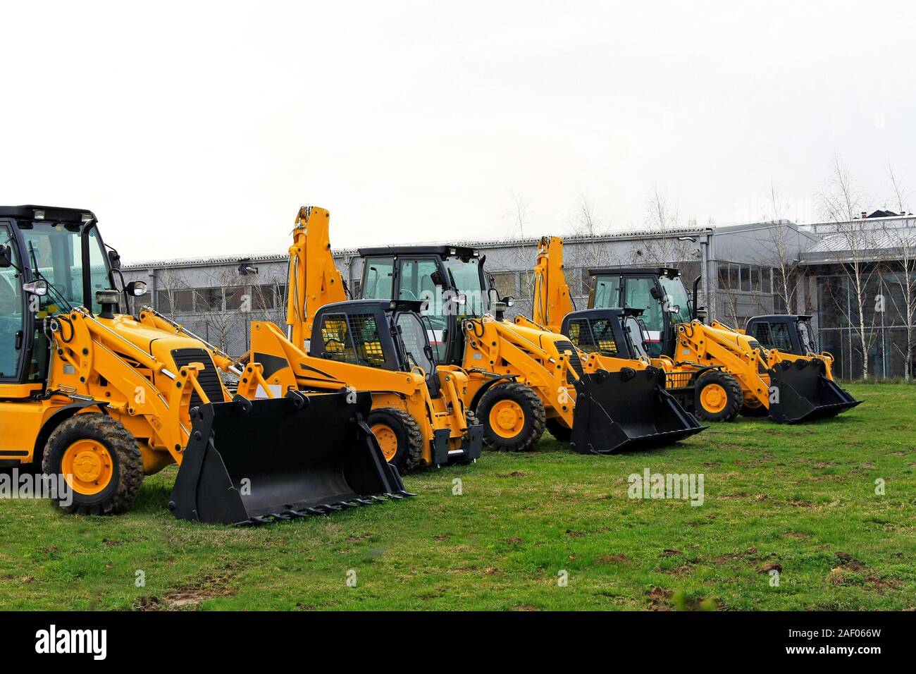 Dozen yellow powerful construction machines in line Stock Photo - Alamy