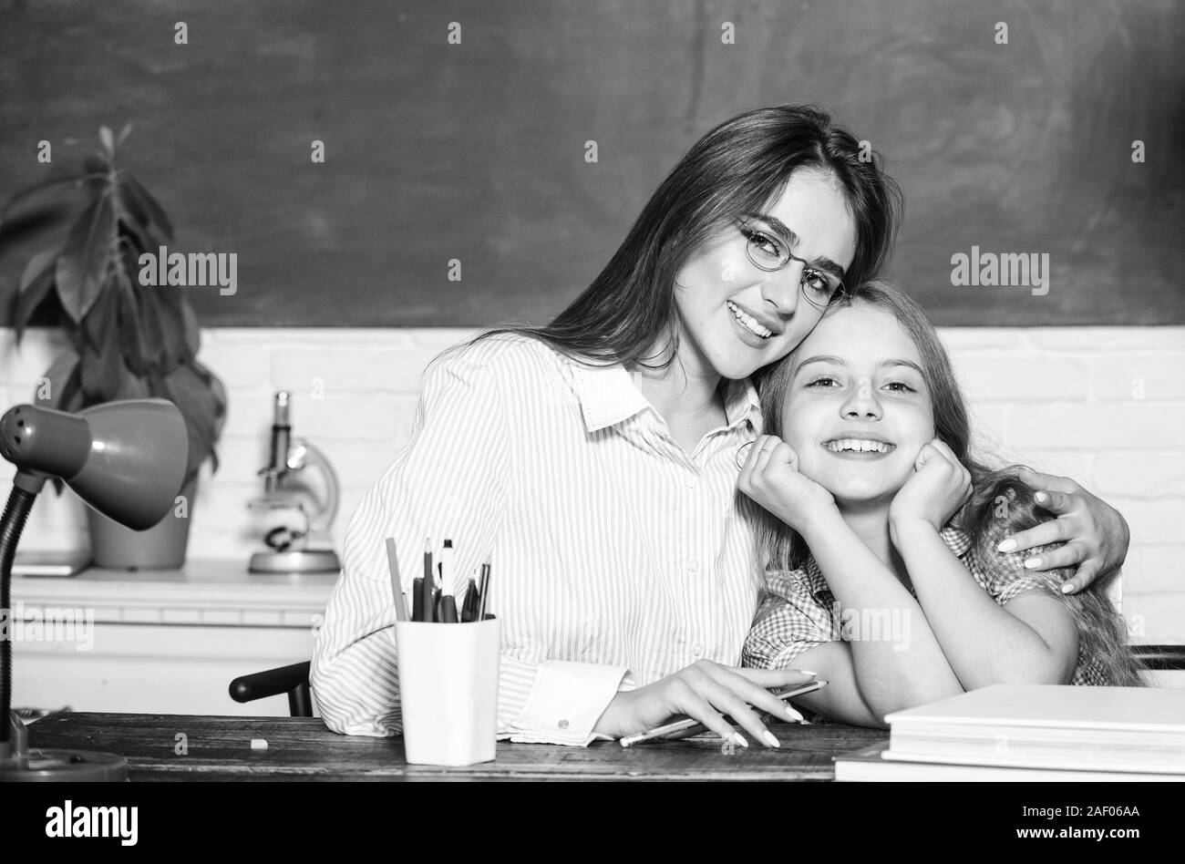 Teacher kind lady with pupil. Doing homework with mom. Little girl and ...