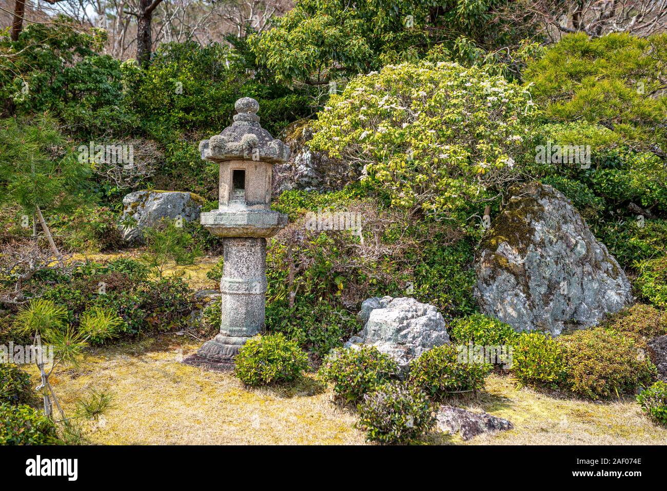Traditional Japanese stone lantern in a garden, taken in an overcast ...