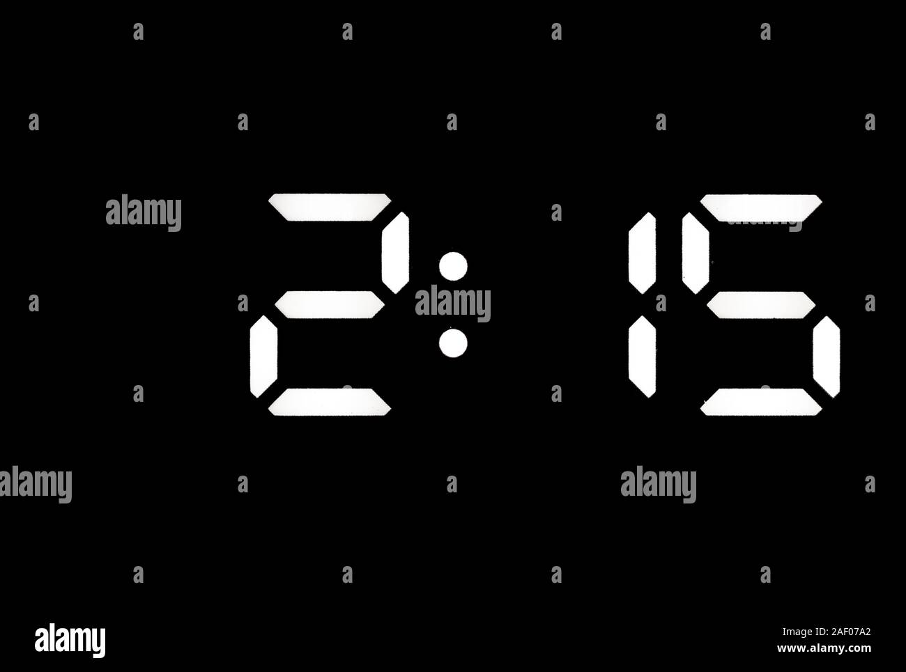 Real white led digital clock on a black background showing time 2:15 ...
