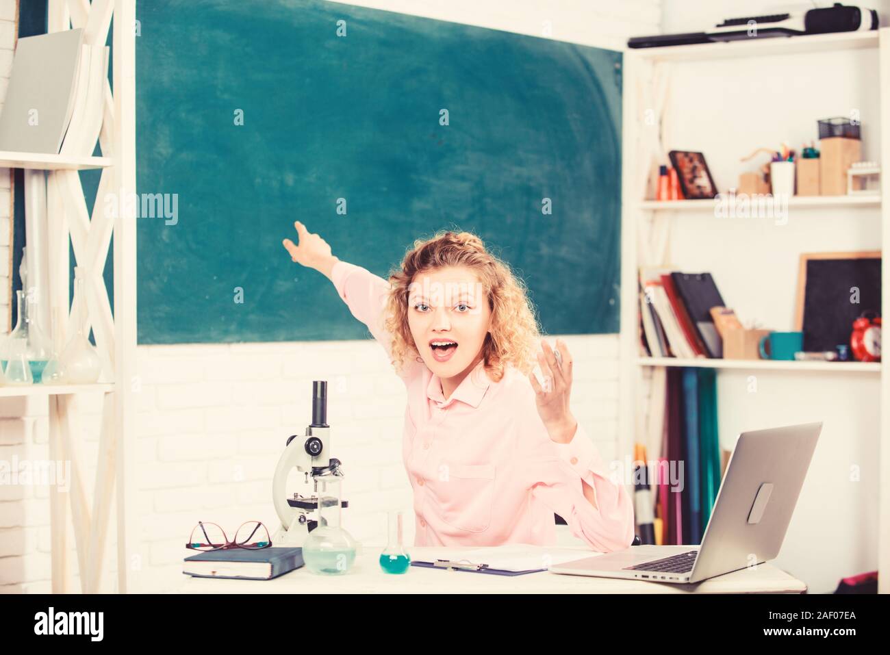 Emotional female teacher educator in classroom chalkboard background ...