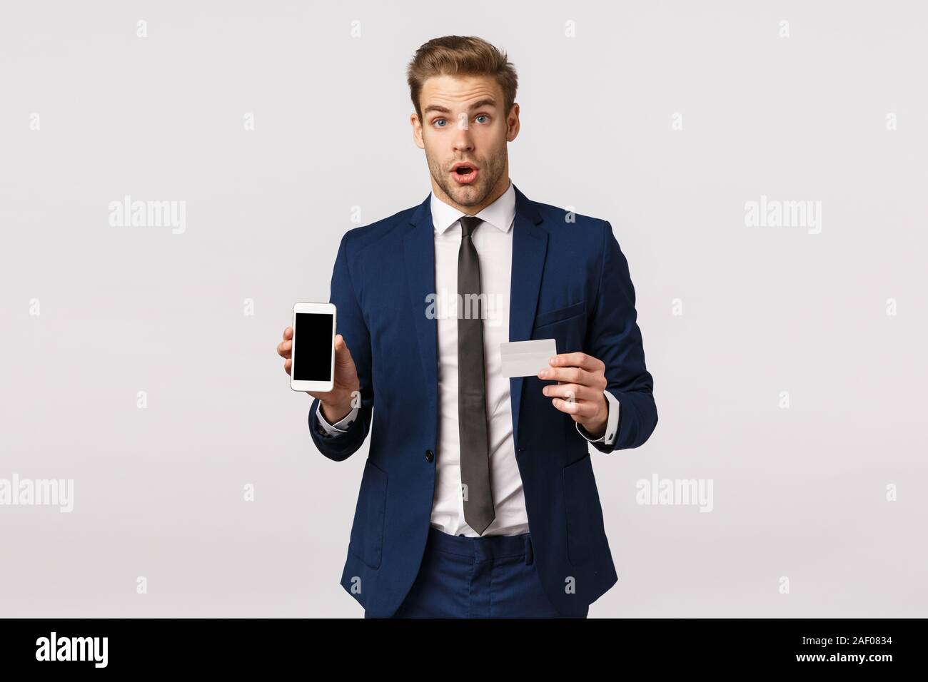 Shocked and impressed handsome businessman in stylish classic blue suit ...