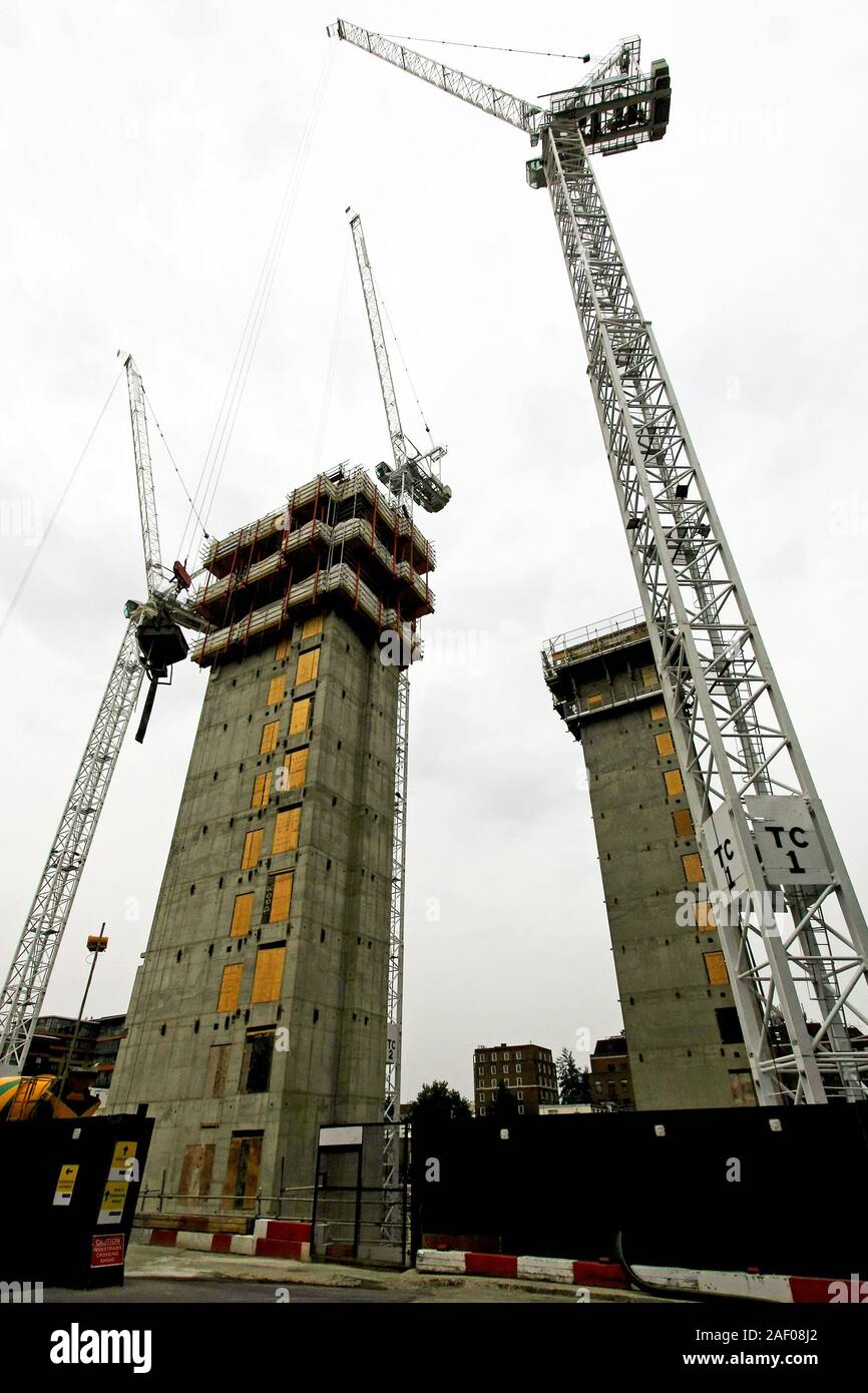 Construction site with tall concrete towers with cranes Stock Photo - Alamy