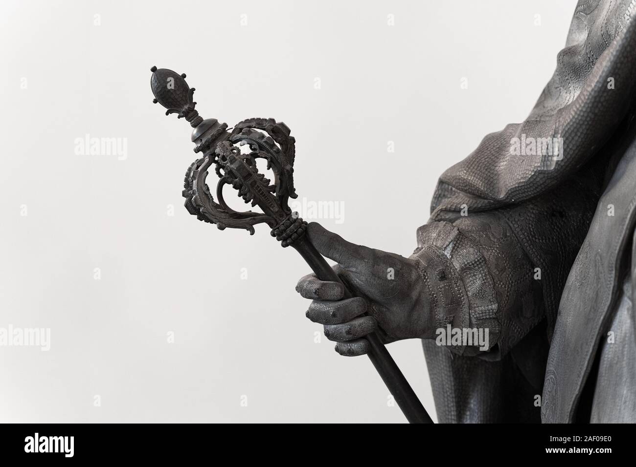 closeup of a black classical statue with hand holding an ornated large ...