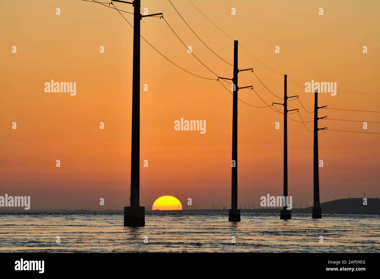 Electrical power lines above the Atlantic Ocean, silhouetted, during ...