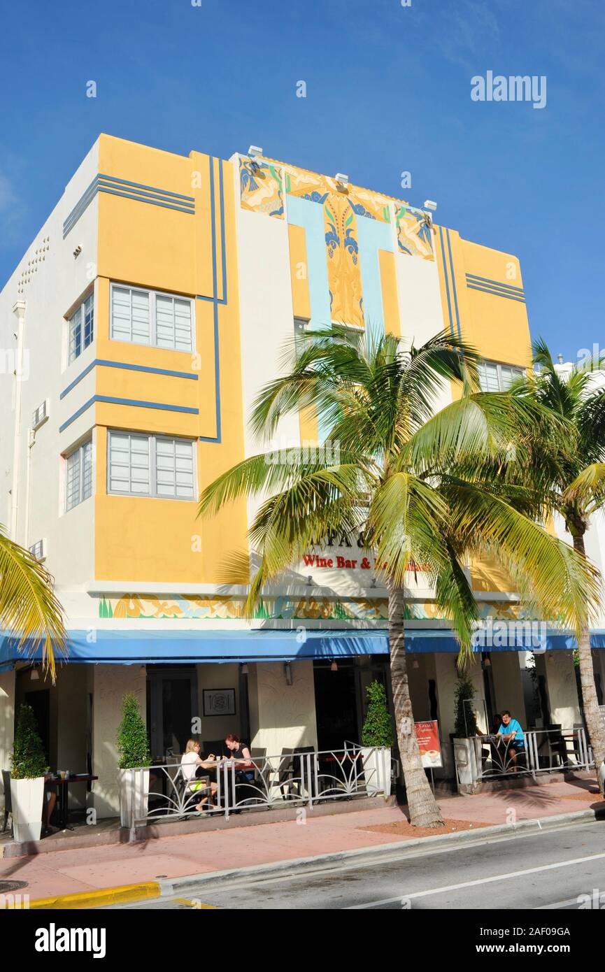 People enjoying meal at bar in outside patio of art deco building in ...