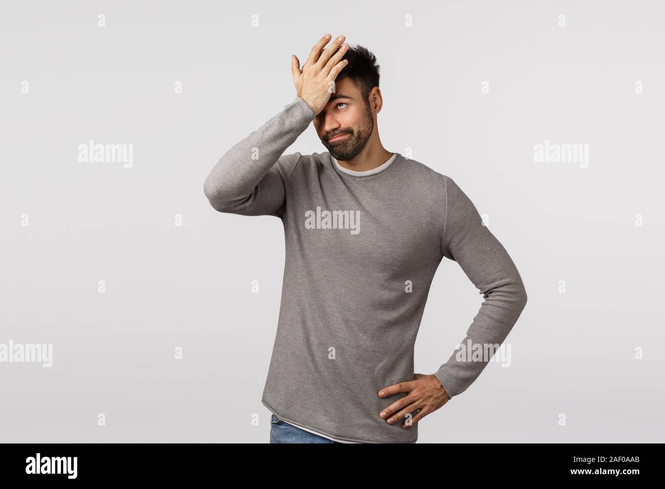 So dumb. Forgetful and displeased, tired bearded man in grey sweater ...