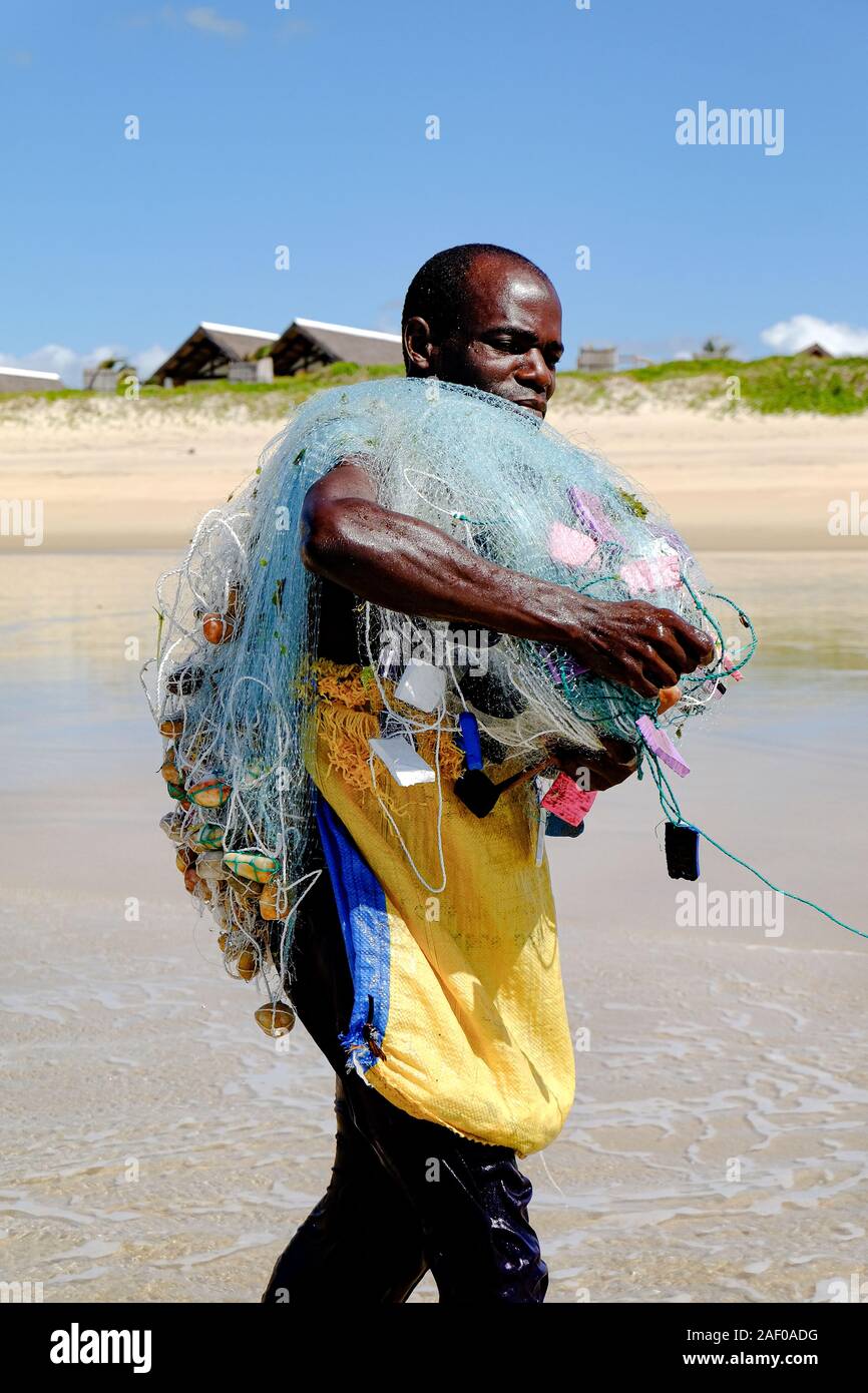 African fisherman leaving the beach with his fishing net Stock Photo ...