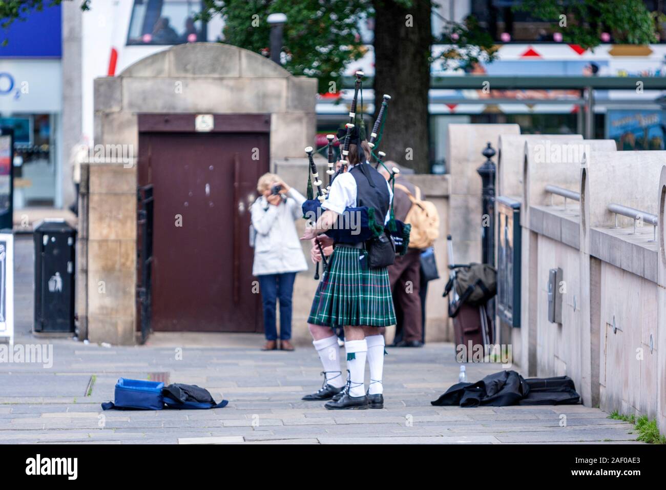 Tourist taking picture to a busker bagpipe in The Royal Scottish ...