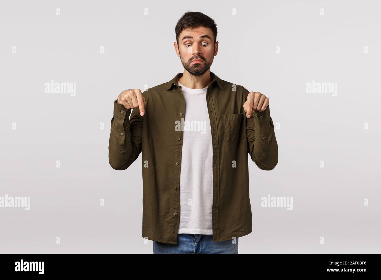 Alarmed man standing in stupor over white background seeing poisoned ...