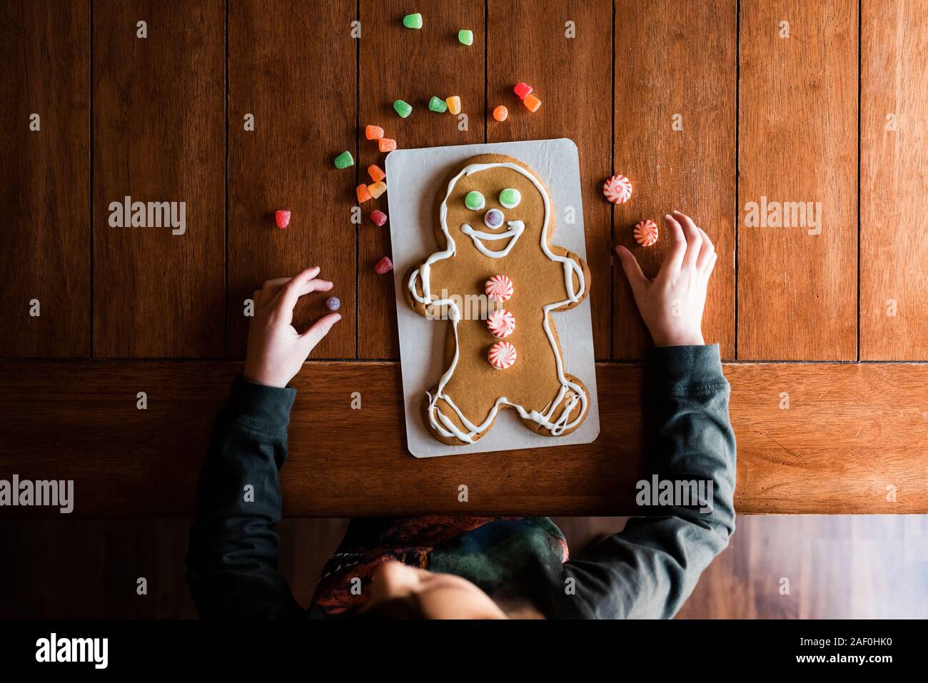 Small kid decorating a gingerbread man on the kitchen table Stock Photo ...