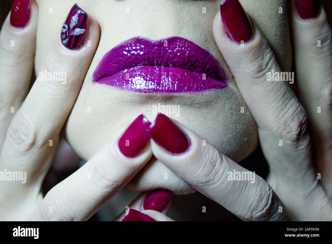 Portrait of woman with hand over face. Red makeup lips and nails Stock ...