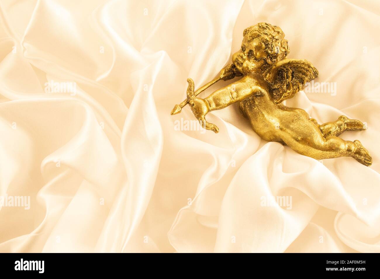 cupidon with arrow on cream,white background Stock Photo - Alamy