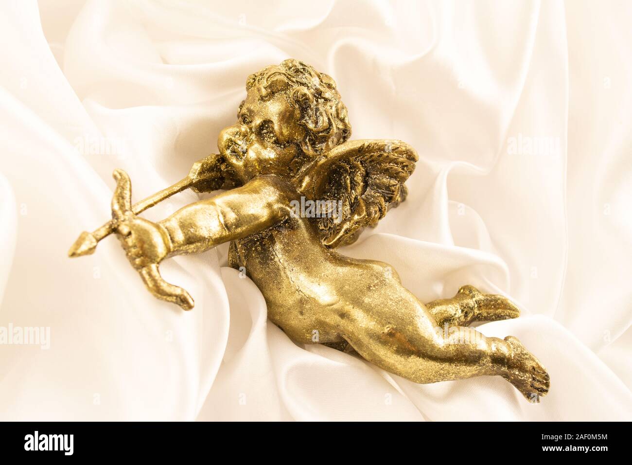 cupidon with arrow on cream,white background Stock Photo - Alamy