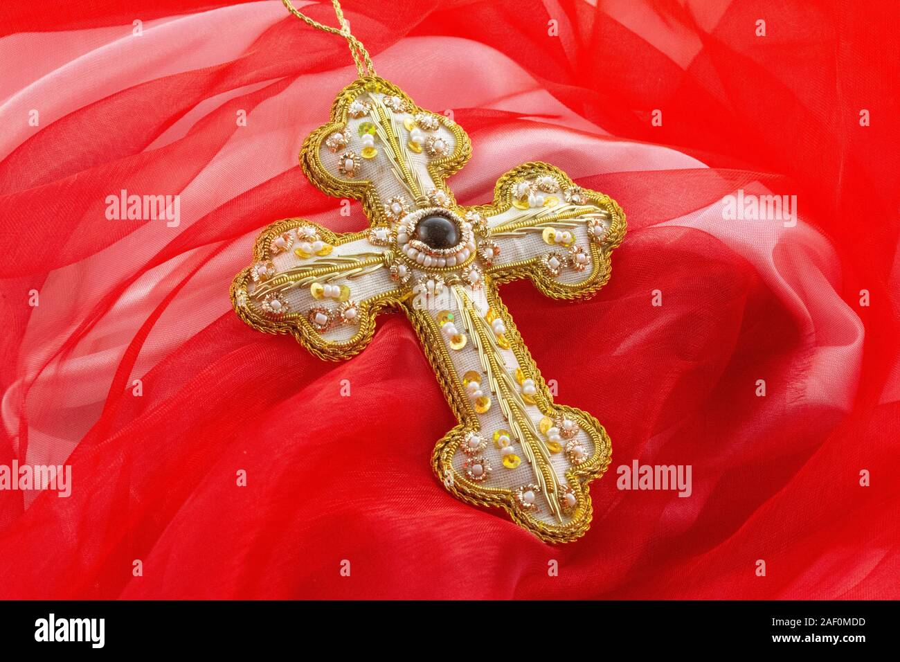 gold hand made cross on red background Stock Photo - Alamy
