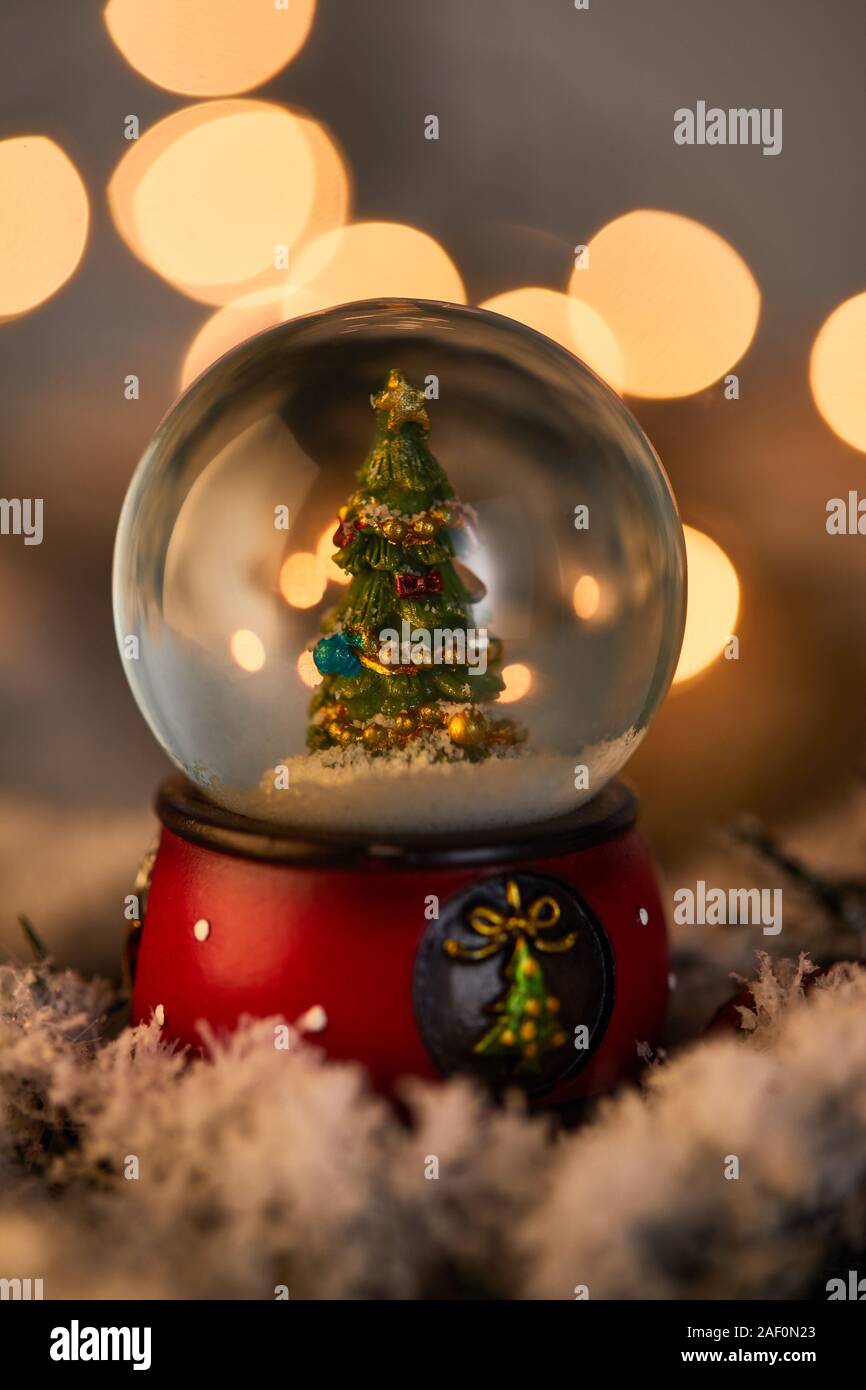 decorative snowball with christmas tree standing in snow with golden ...