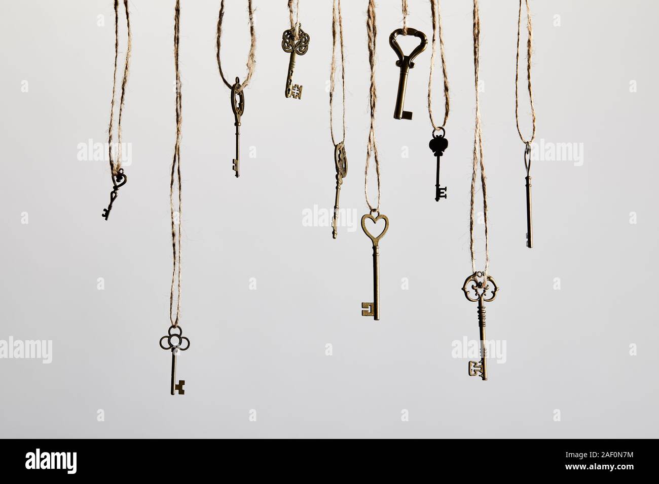 vintage keys hanging on ropes isolated on white Stock Photo - Alamy
