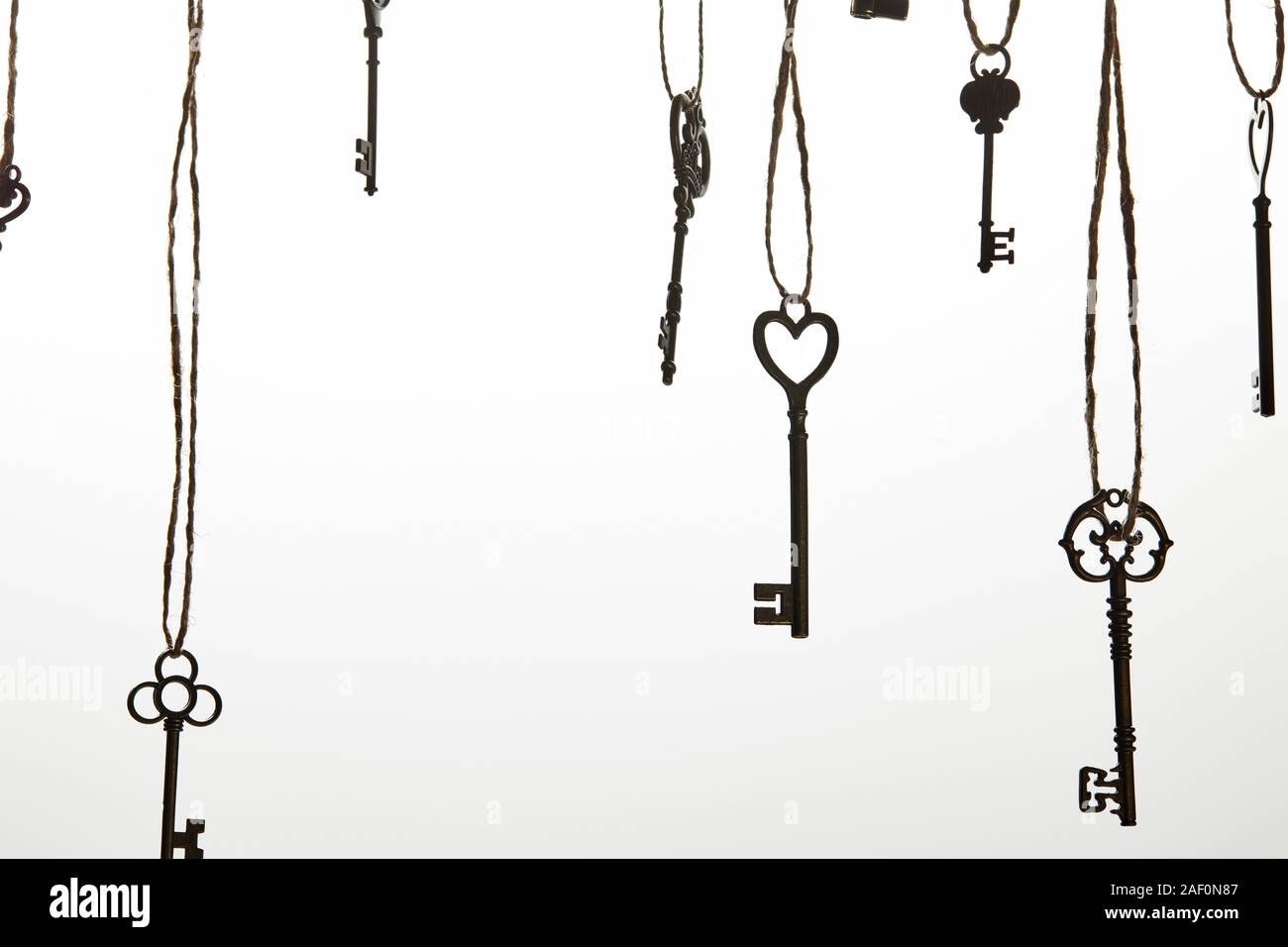 vintage keys hanging on ropes isolated on white Stock Photo - Alamy