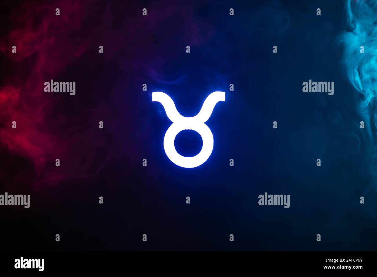 blue illuminated Taurus zodiac sign with colorful smoke on background ...