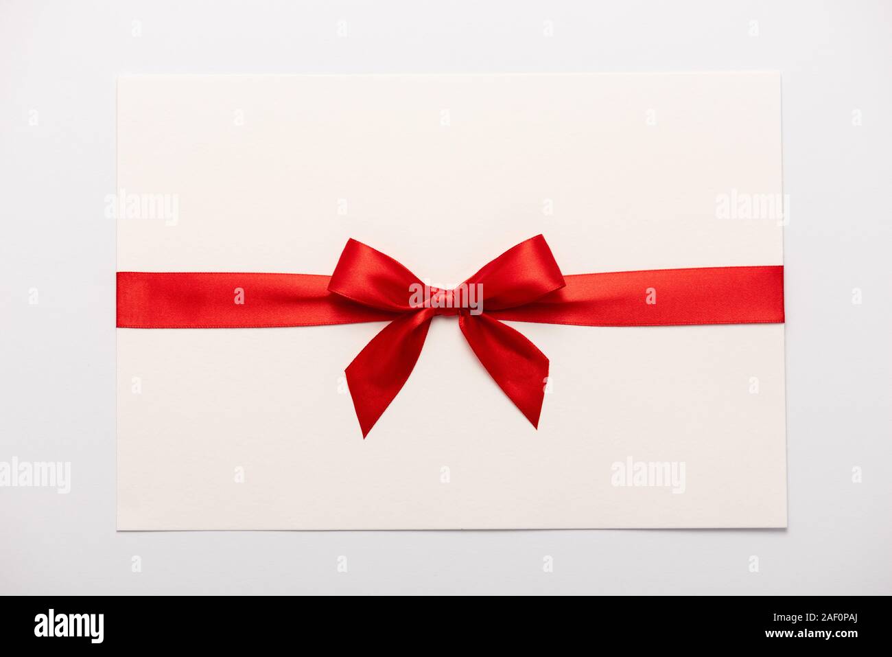 top view of red satin bow on envelope isolated on white Stock Photo - Alamy