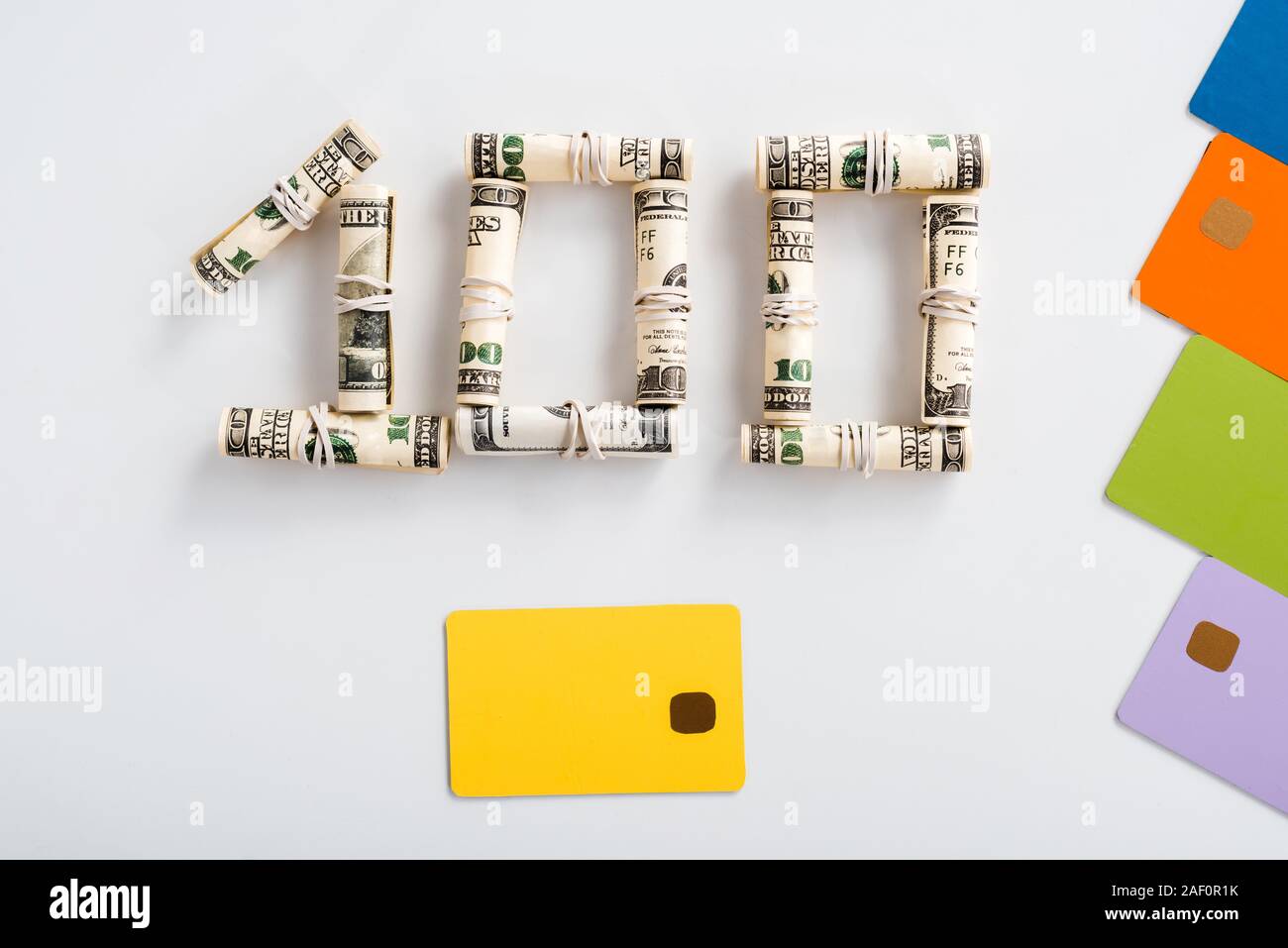 top view of one hundred dollar banknotes in cash rolls near colorful ...