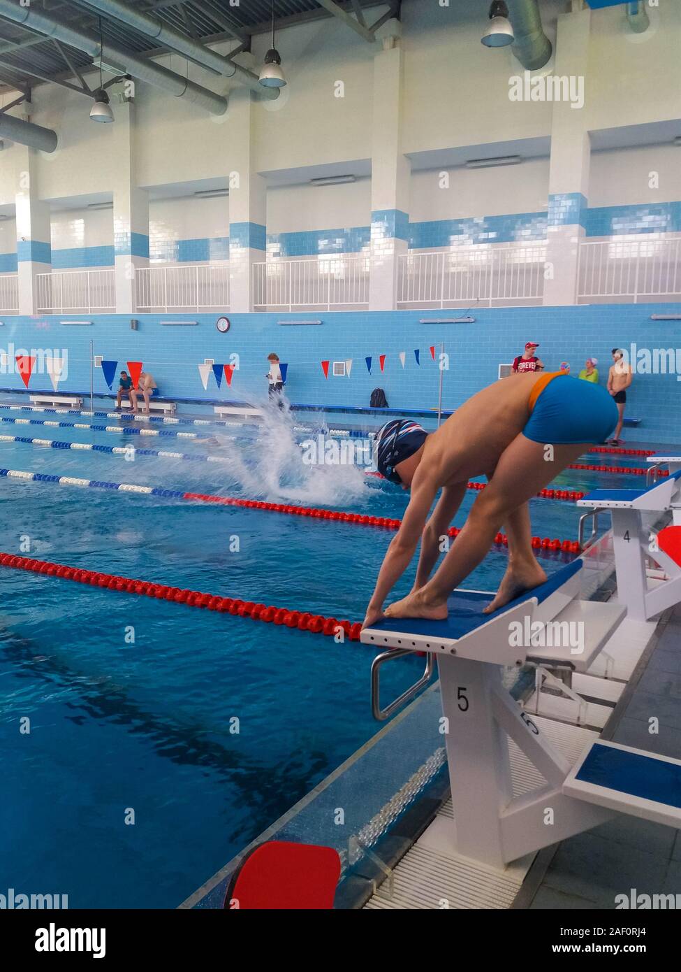 Training swimmers. A teenage boy is preparing to jump into the pool ...