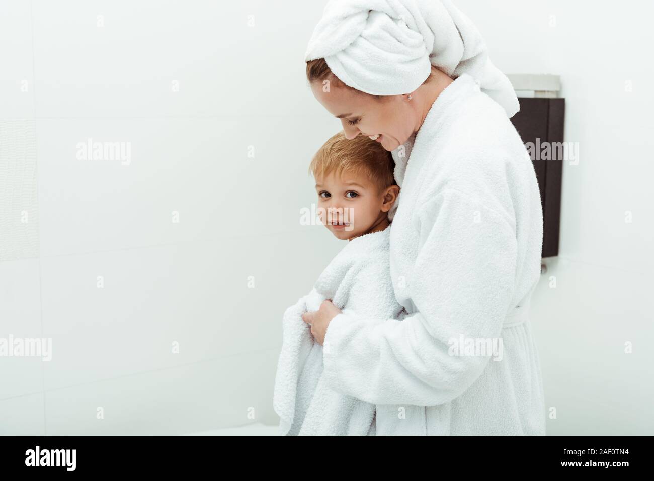 happy mother smiling while hugging toddler son in bathroom Stock Photo ...