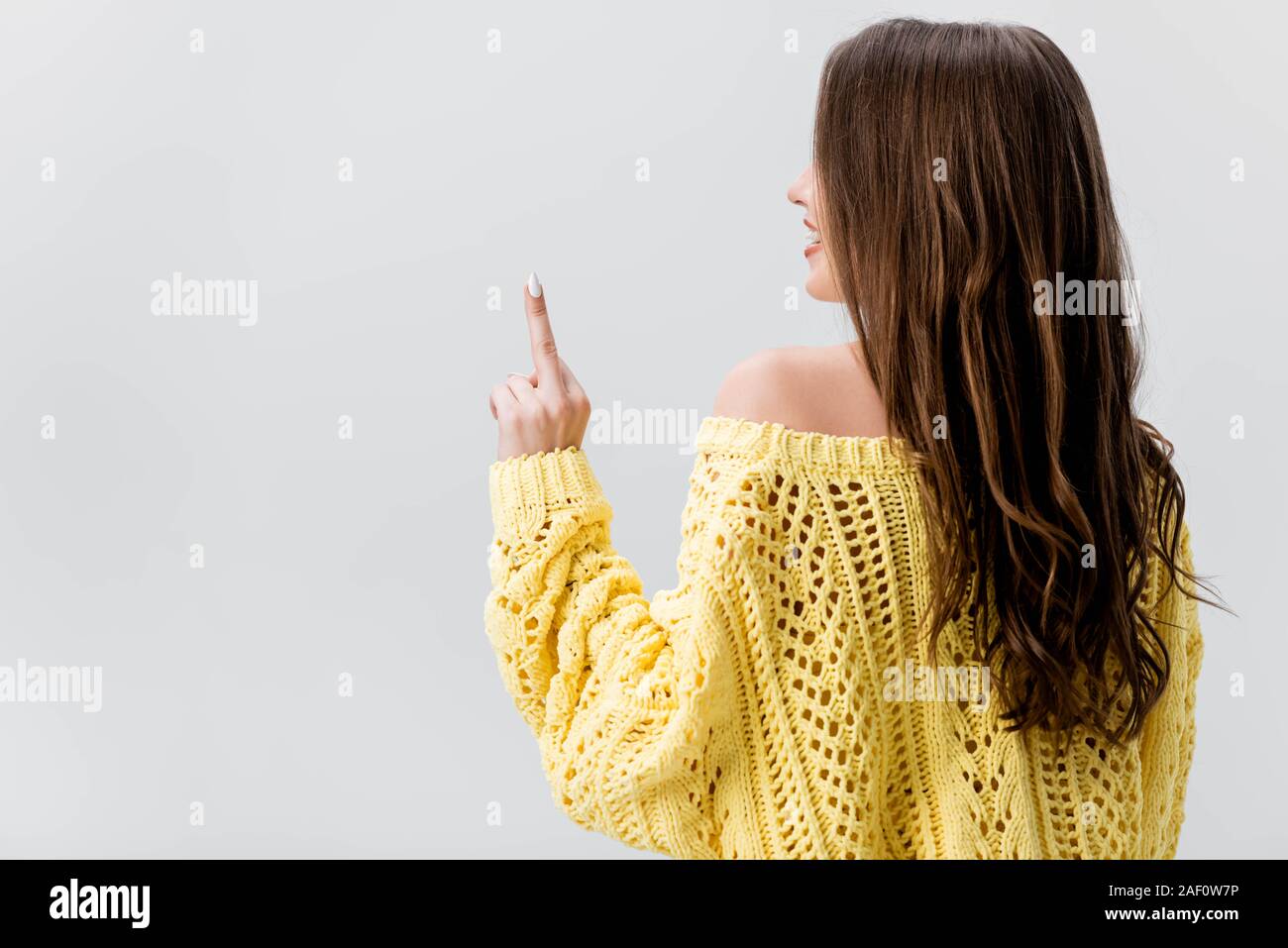 back view of girl in yellow sweater showing middle finger isolated on ...