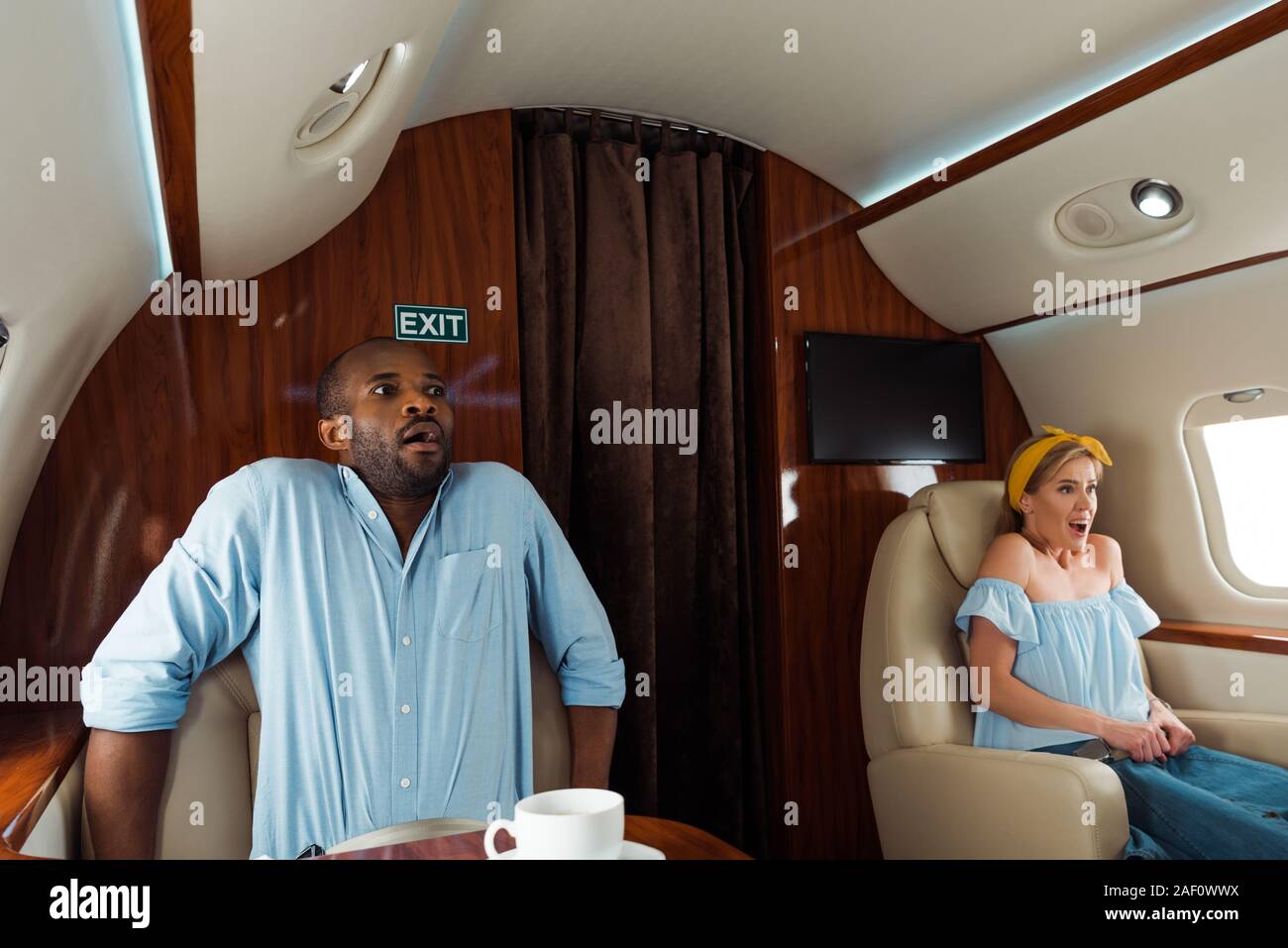 scared african american man and woman with fear of flight in private ...