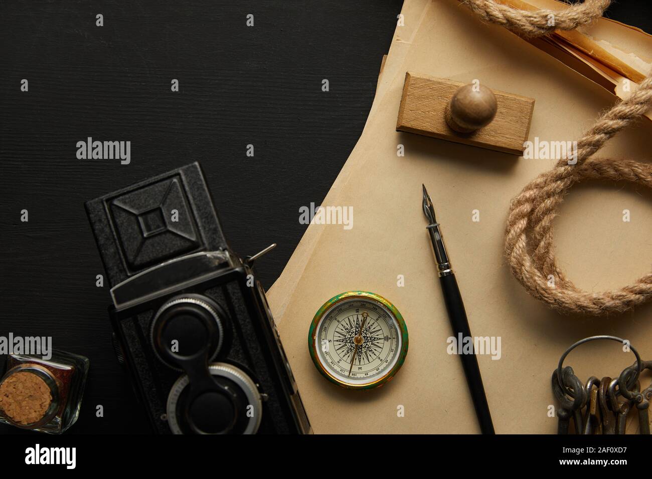 top view of vintage camera, paper, fountain pen, compass, stamp and ...