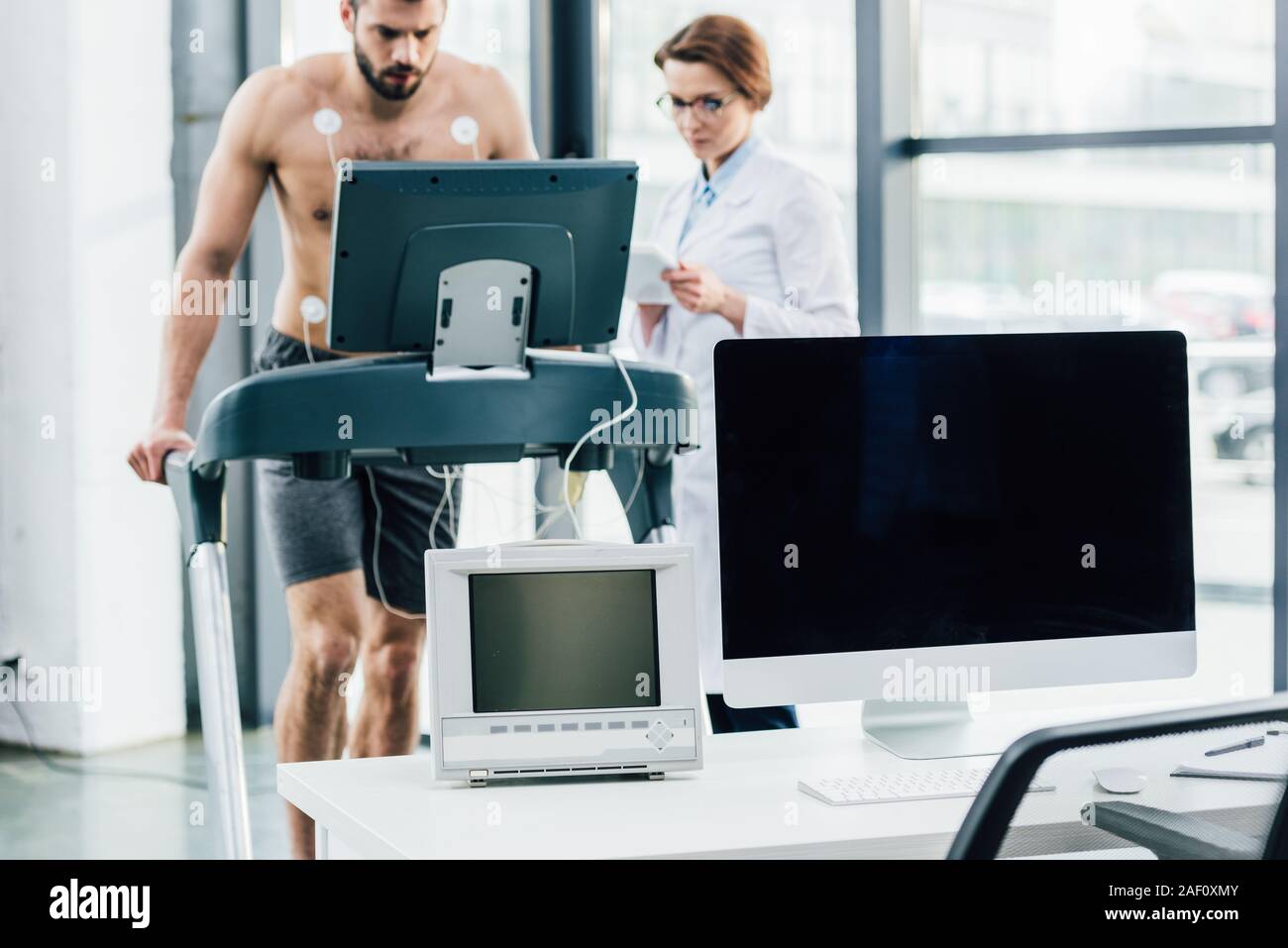 computer with blank screen and doctor conducting endurance test with ...