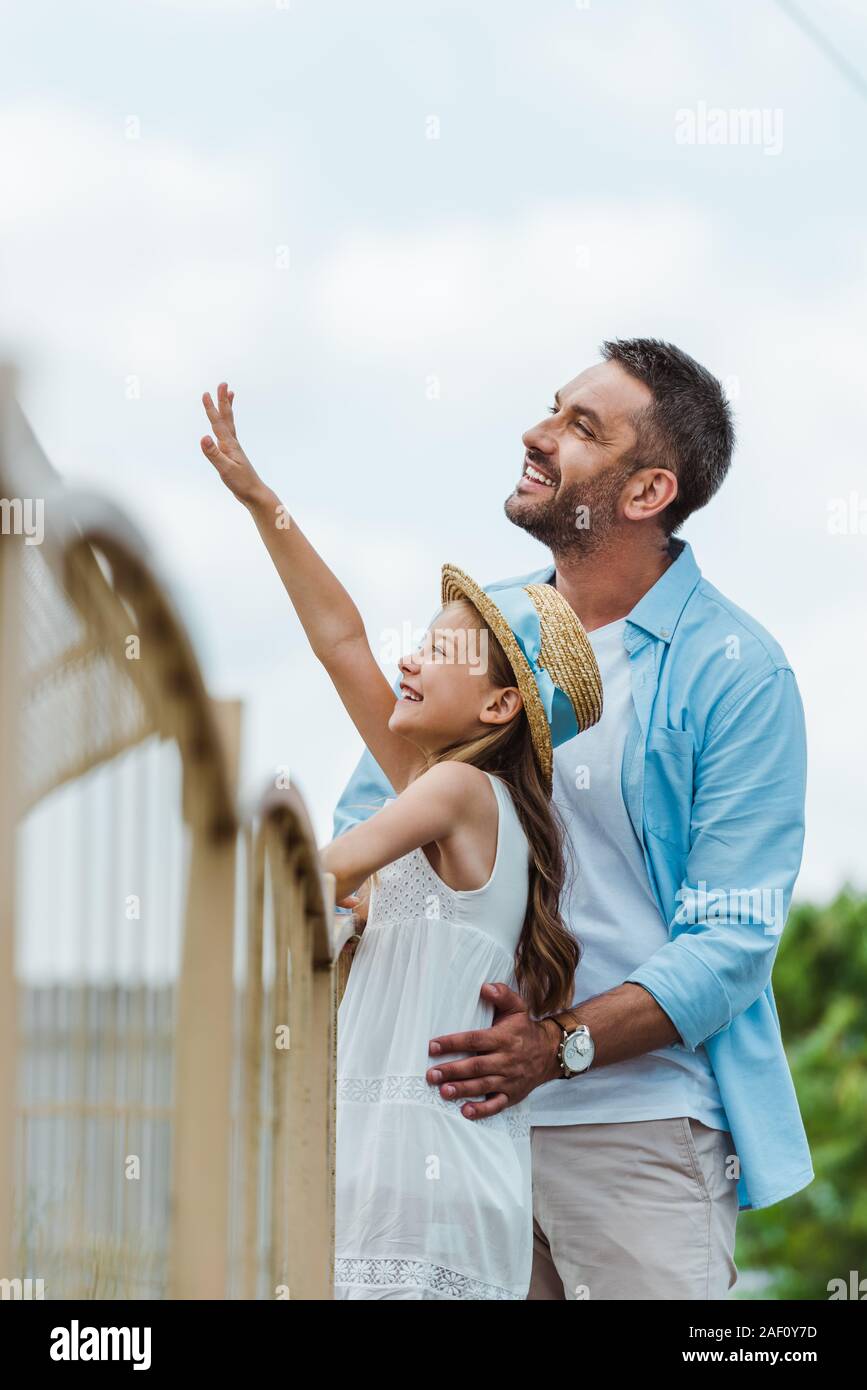 cheerful kid gesturing standing standing with happy man Stock Photo - Alamy