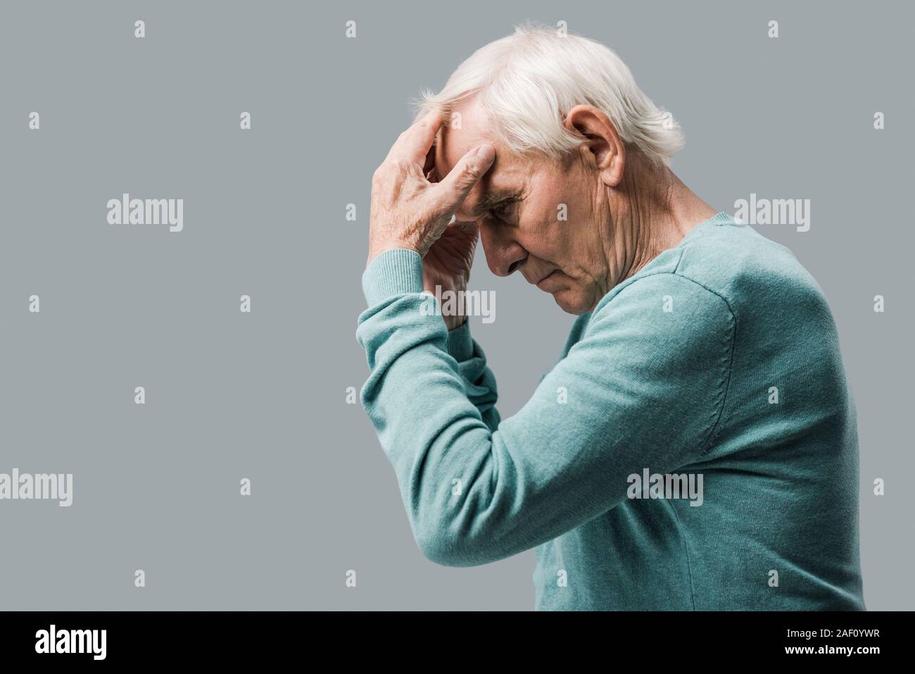 exhausted and sad retired man touching head isolated on grey Stock ...