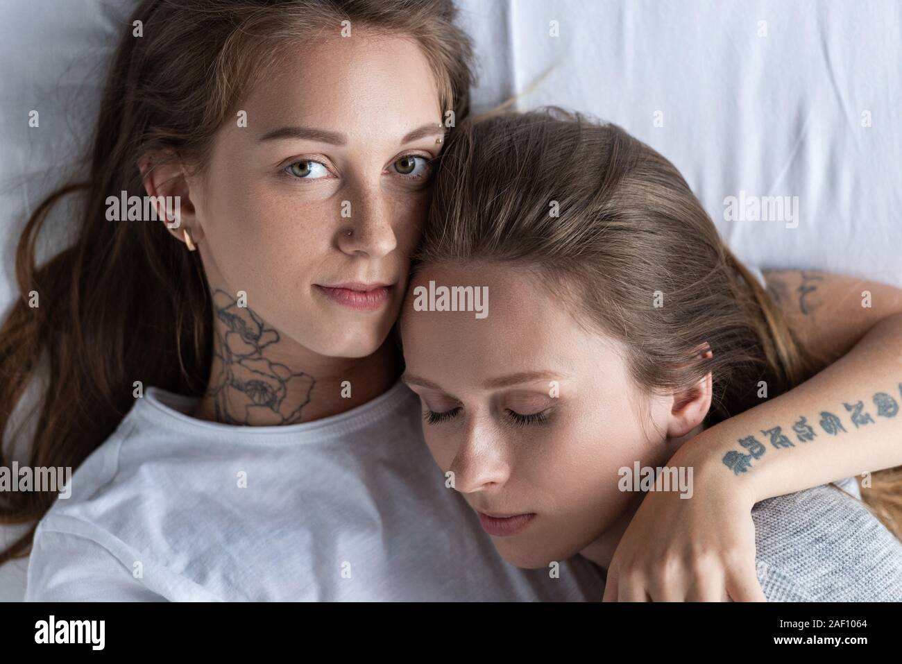 top view of two lesbians embracing while lying on bed Stock Photo - Alamy