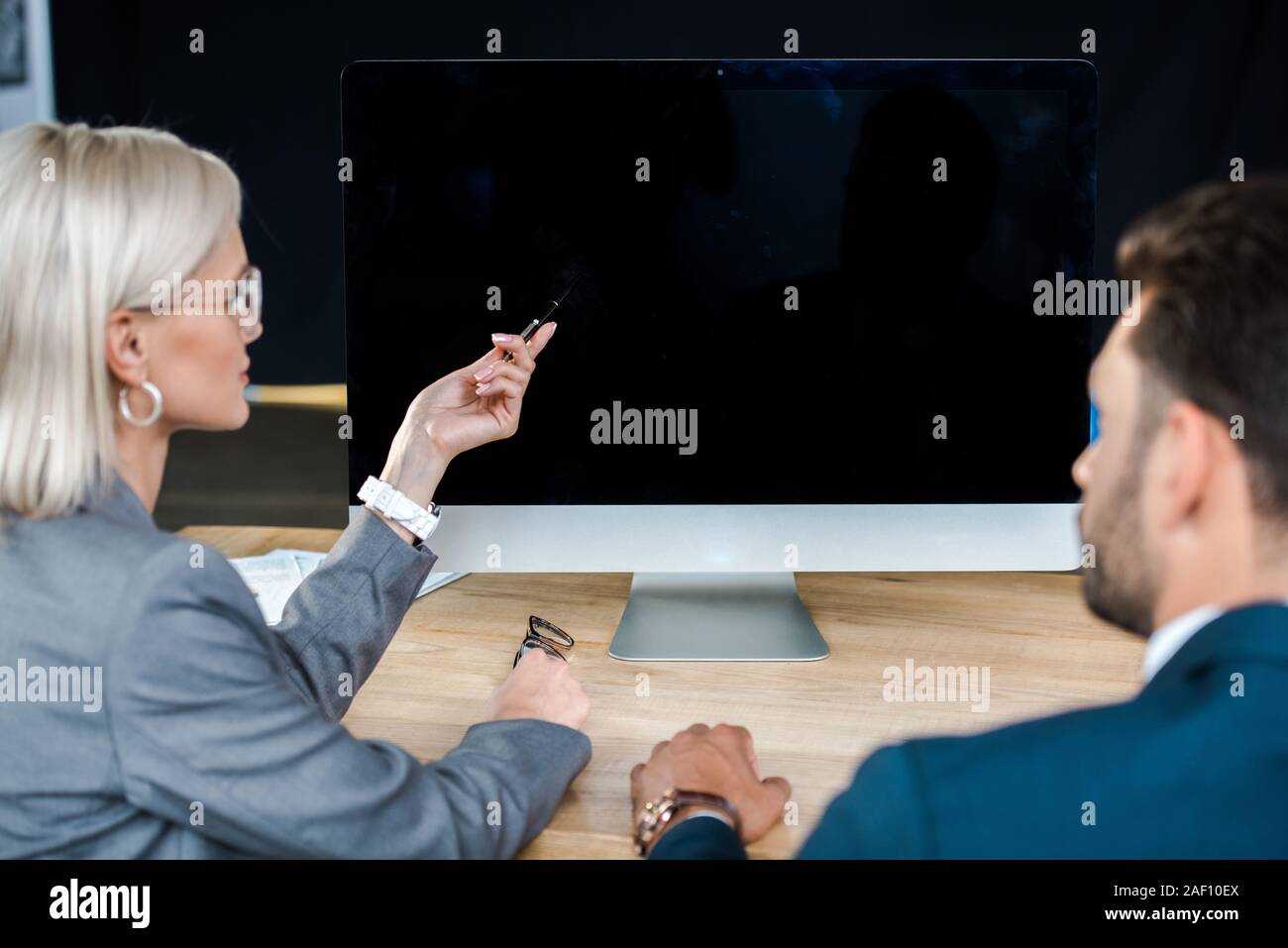 selective focus of computer monitor with blank screen near businessman ...