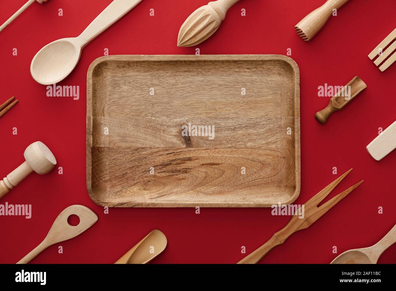top view of natural rectangular wooden dish on red background with ...