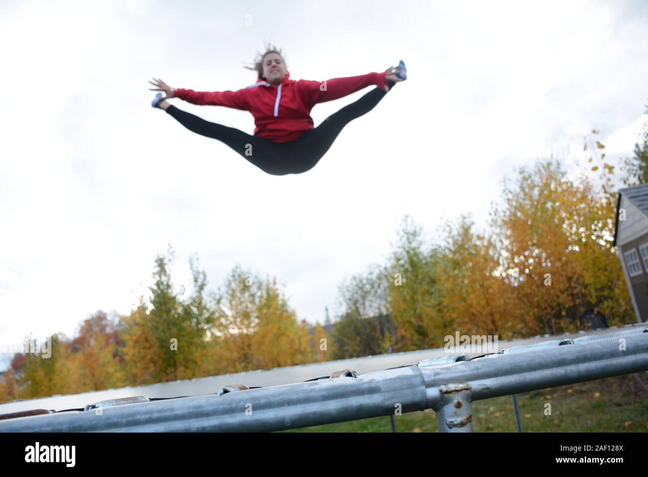 Teenage girl doing acrobatics on trampoline Stock Photo - Alamy