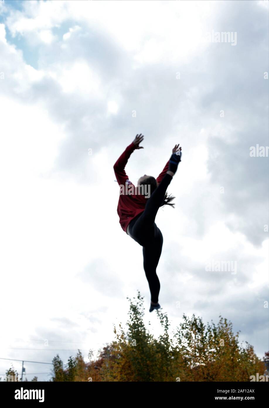 Teenage girl doing acrobatics on trampoline Stock Photo - Alamy