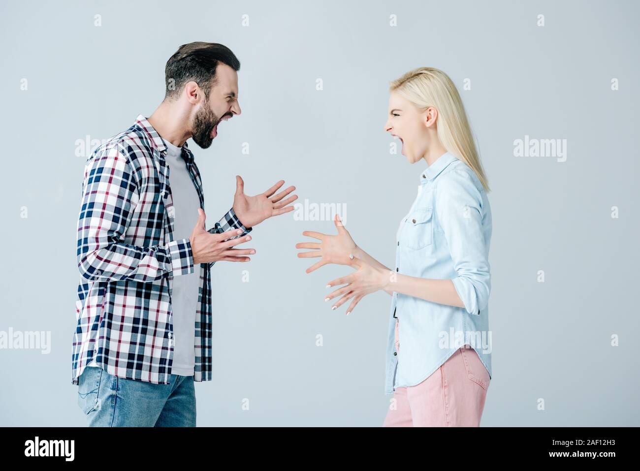 man and woman shouting and gesturing isolated on grey Stock Photo - Alamy
