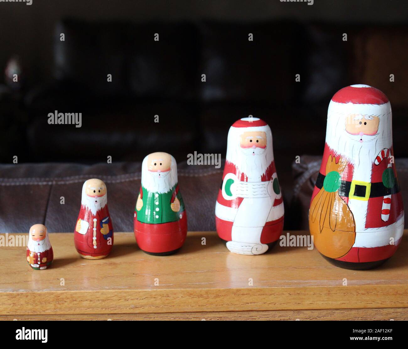 Five nesting Santa Claus wood figures resting on a wood ledge Stock ...