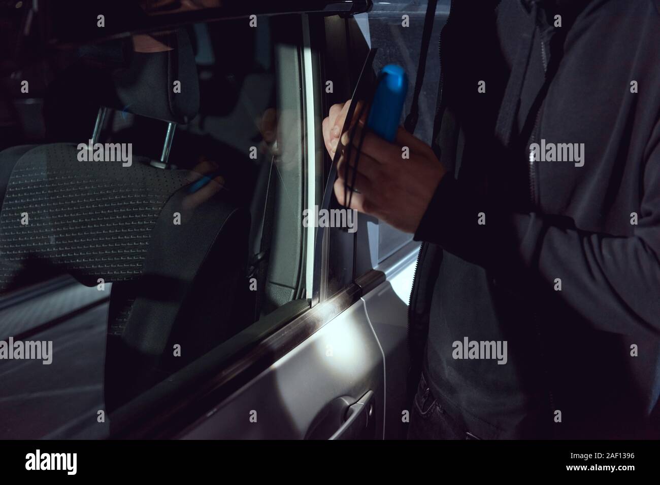 thief intruding car with crowbar and flashlight Stock Photo - Alamy