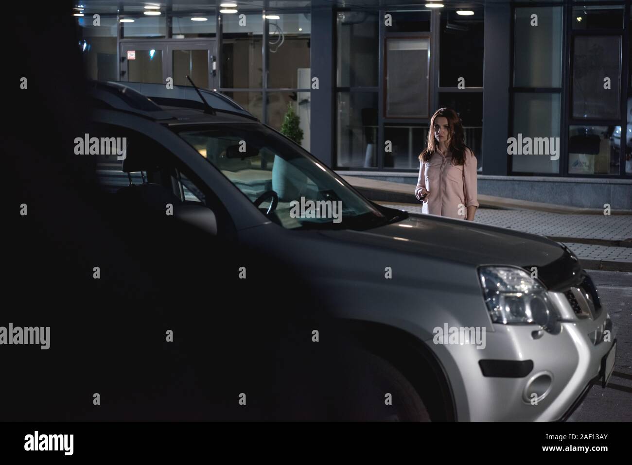 scared woman near car in parking lot at night Stock Photo - Alamy