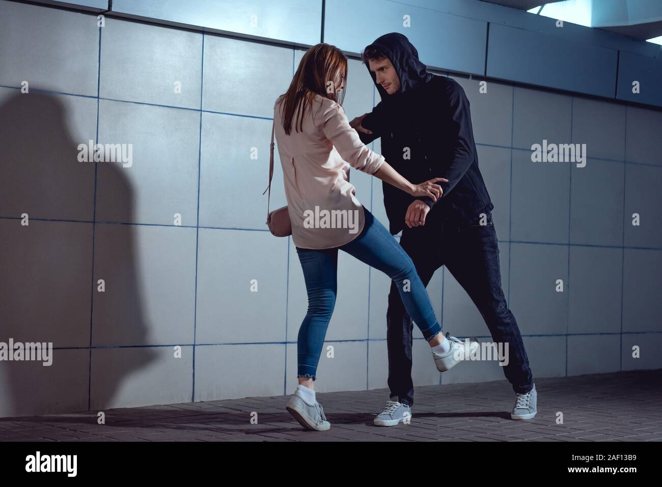 woman defending herself from attacking thief in underpass Stock Photo ...