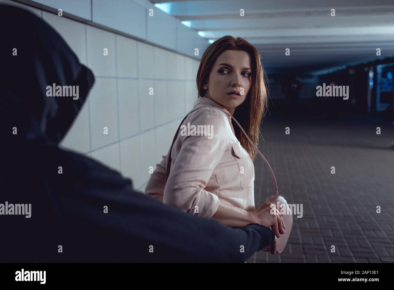 thief stealing bag from beautiful woman in underpass Stock Photo - Alamy