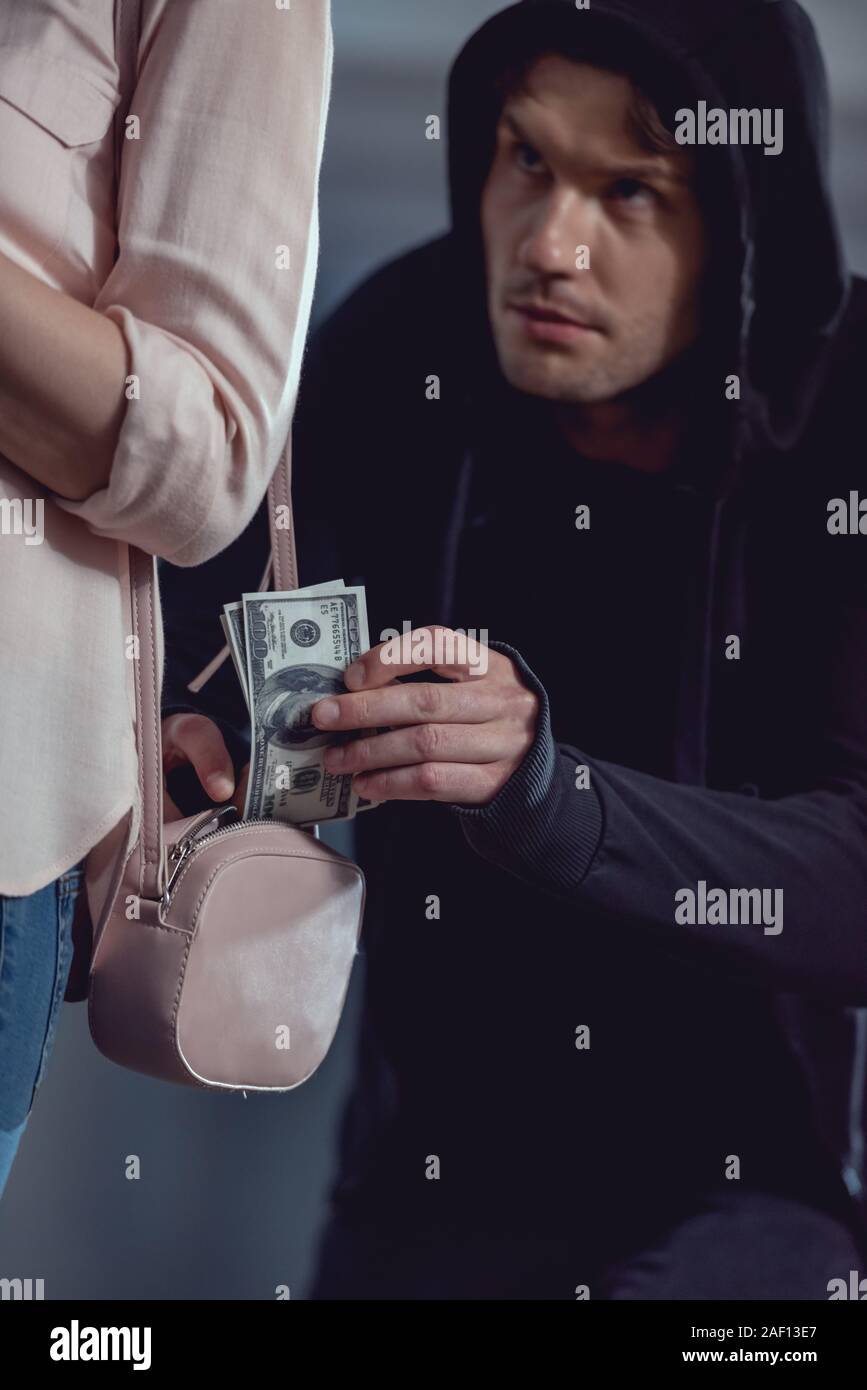thief stealing dollar banknotes from bag of woman Stock Photo - Alamy