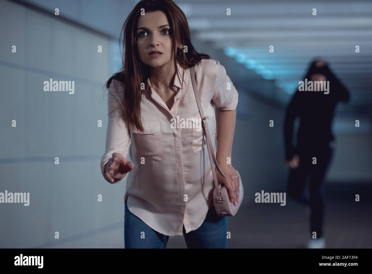 beautiful woman running from thief in underpass Stock Photo - Alamy
