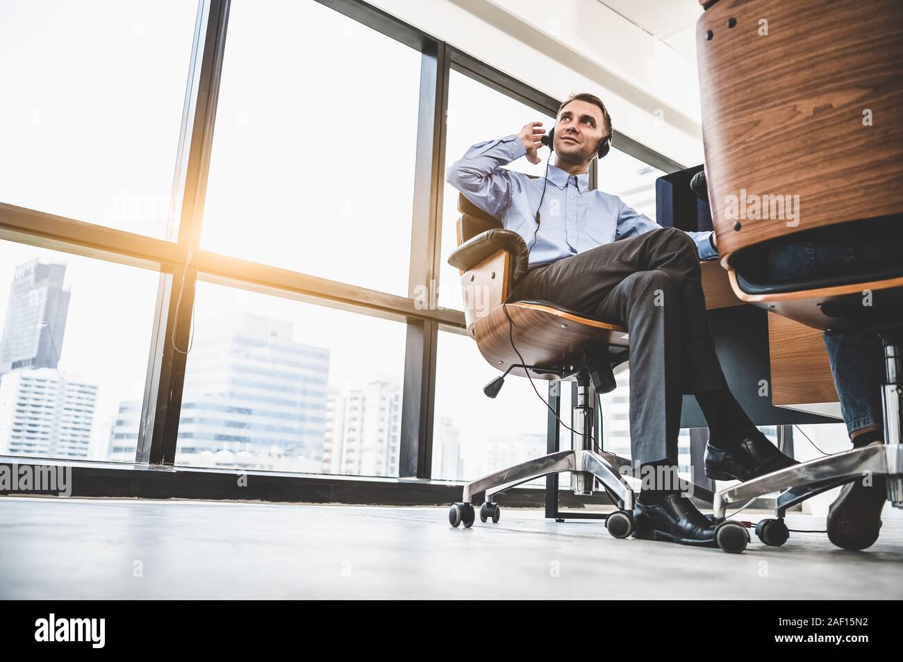 Portrait of happy handsome business man with headset in modern office ...