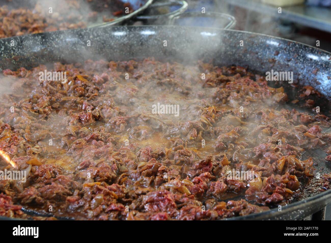 Beef cooking in frying pan at Borough Market, London UK Stock Photo - Alamy