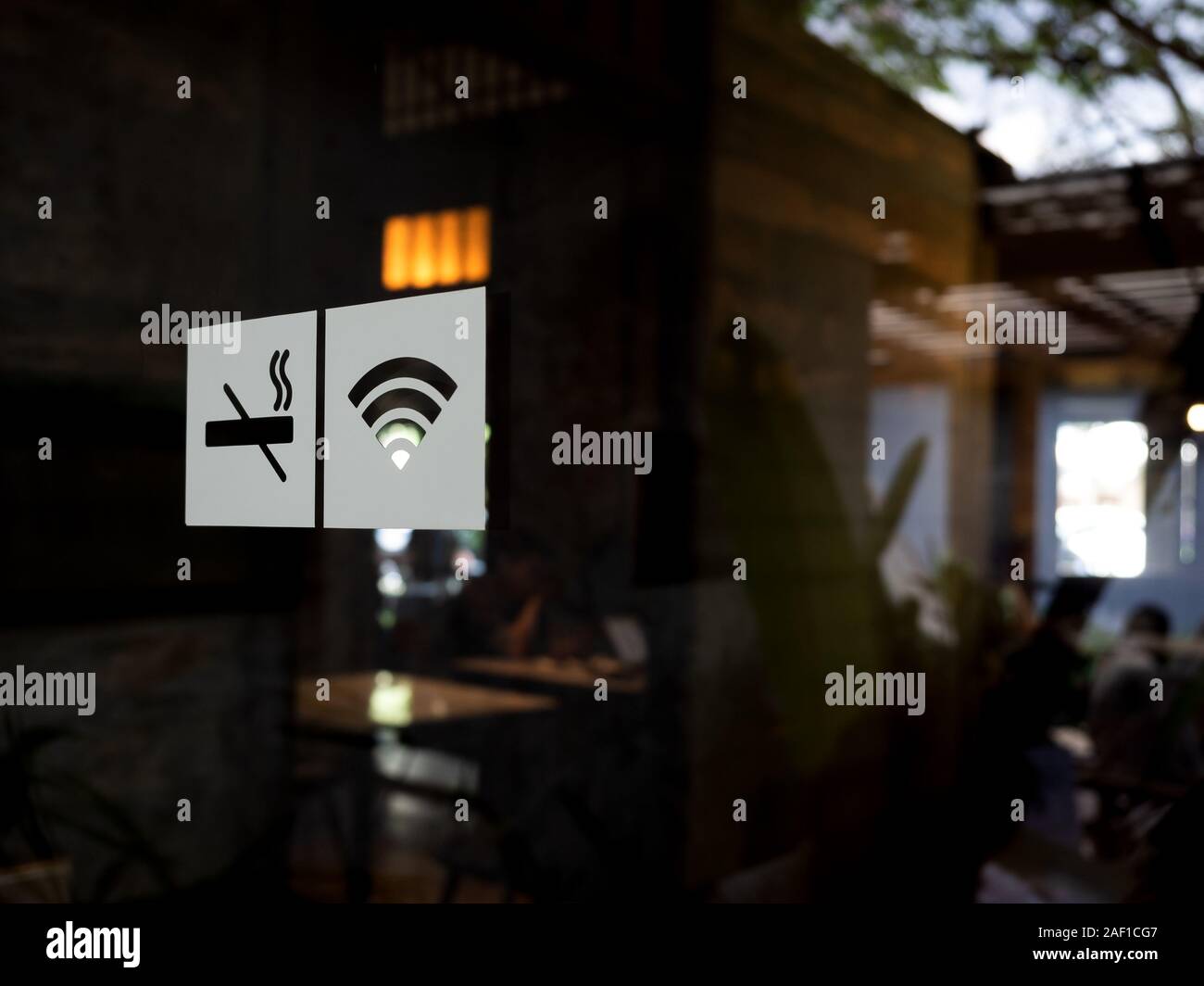 Signs on glass door. No smoking sign, wireless signal icon sign for ...